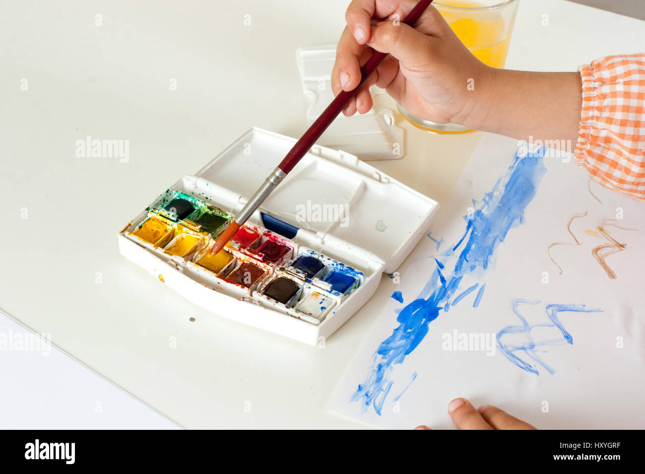 Hand of child with paintbrush taking paint on watercolor set Stock ...