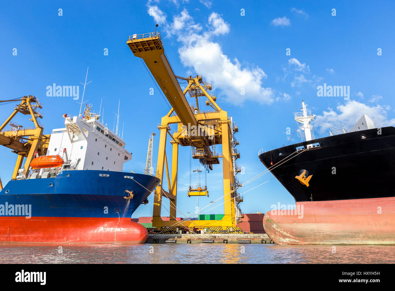 Container cargo freight ship with working crane loading bridge in ...