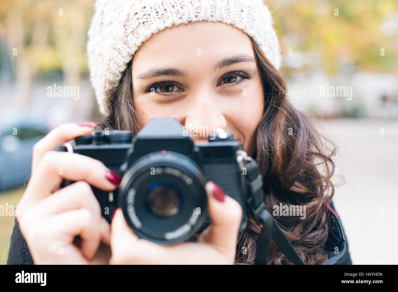 Portrait of a young beautiful woman with an analog camera in autumn ...