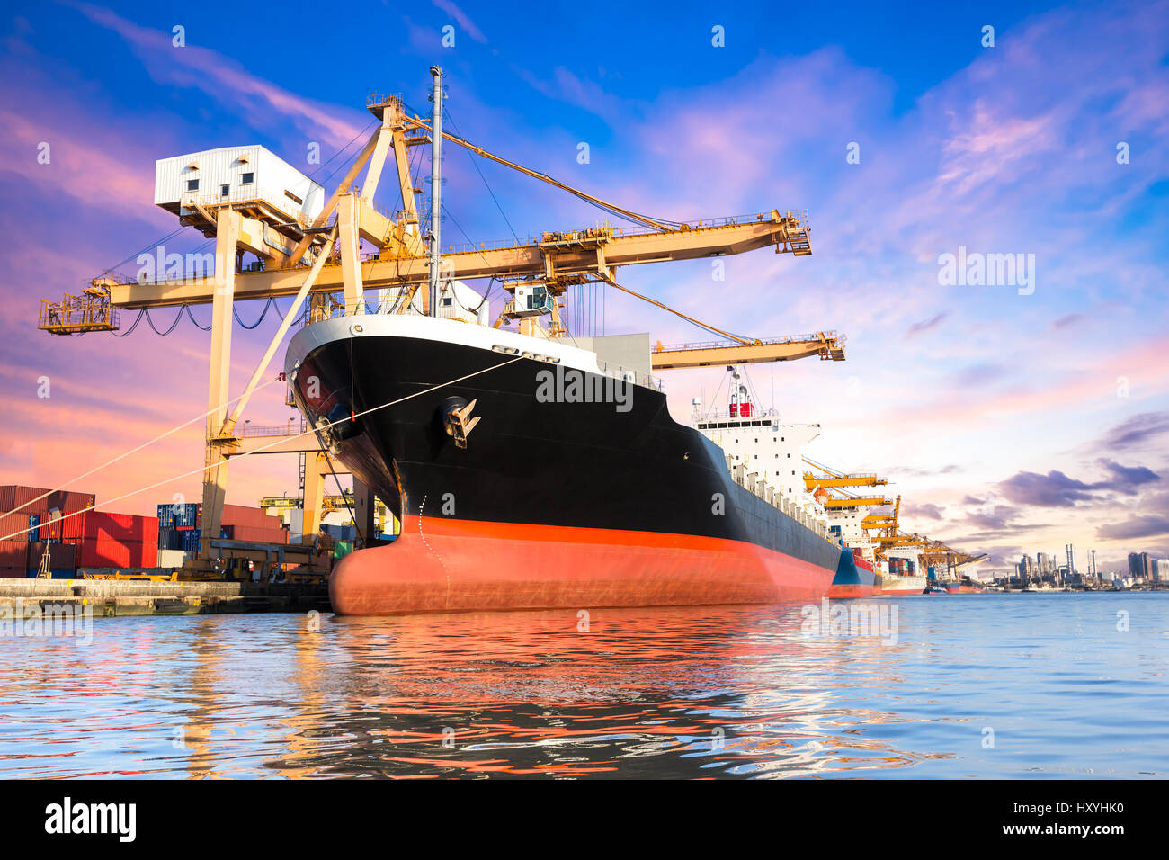 Container cargo freight ship with working crane loading bridge in ...
