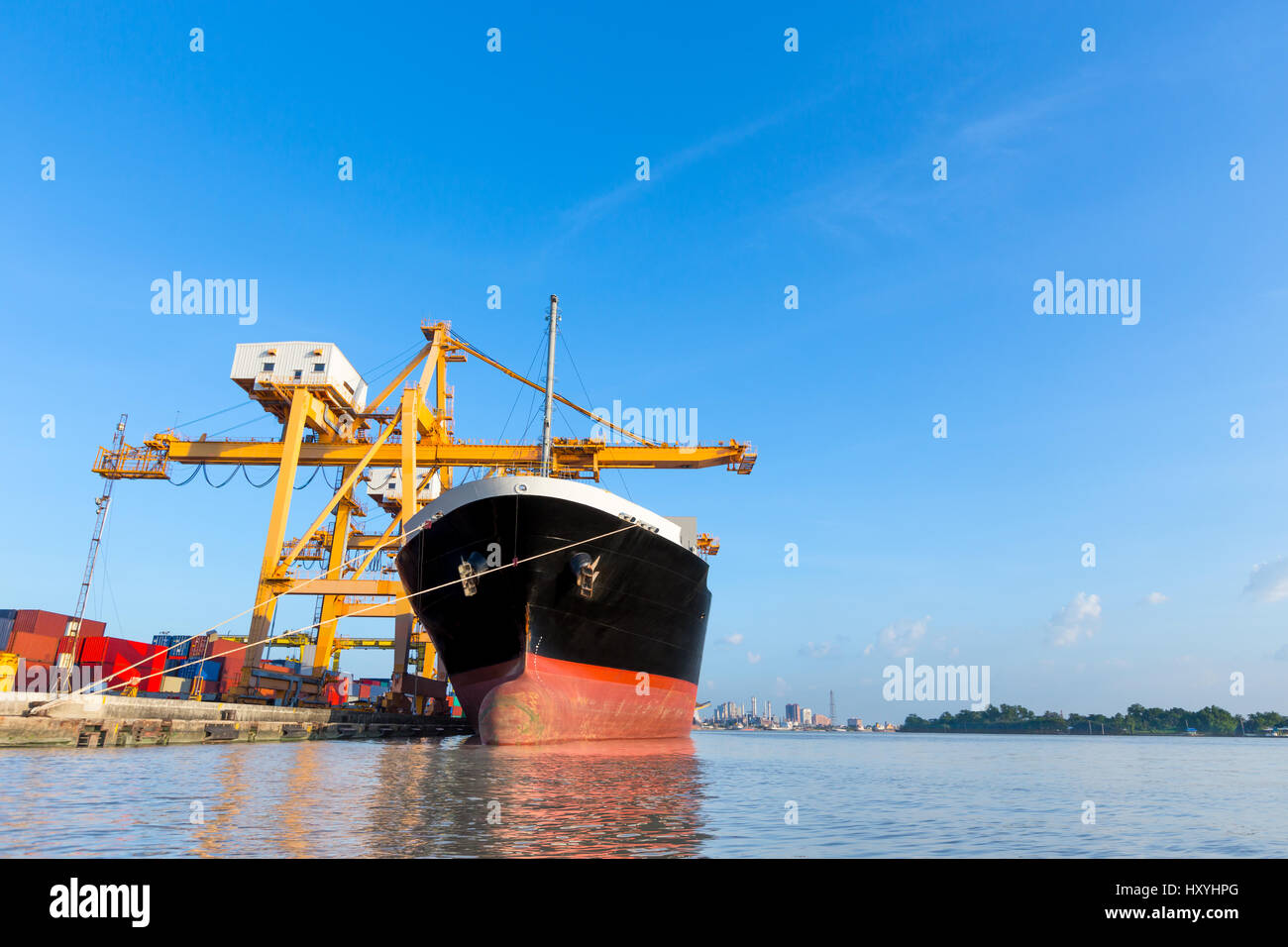 Container cargo freight ship with working crane loading bridge in ...