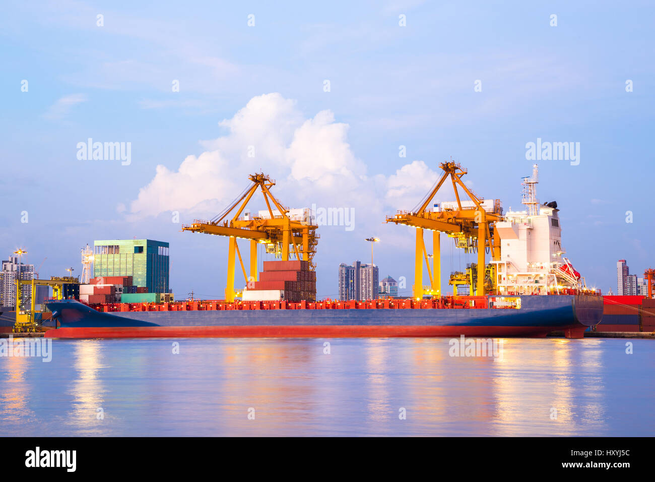 Container cargo freight ship with working crane loading bridge in ...