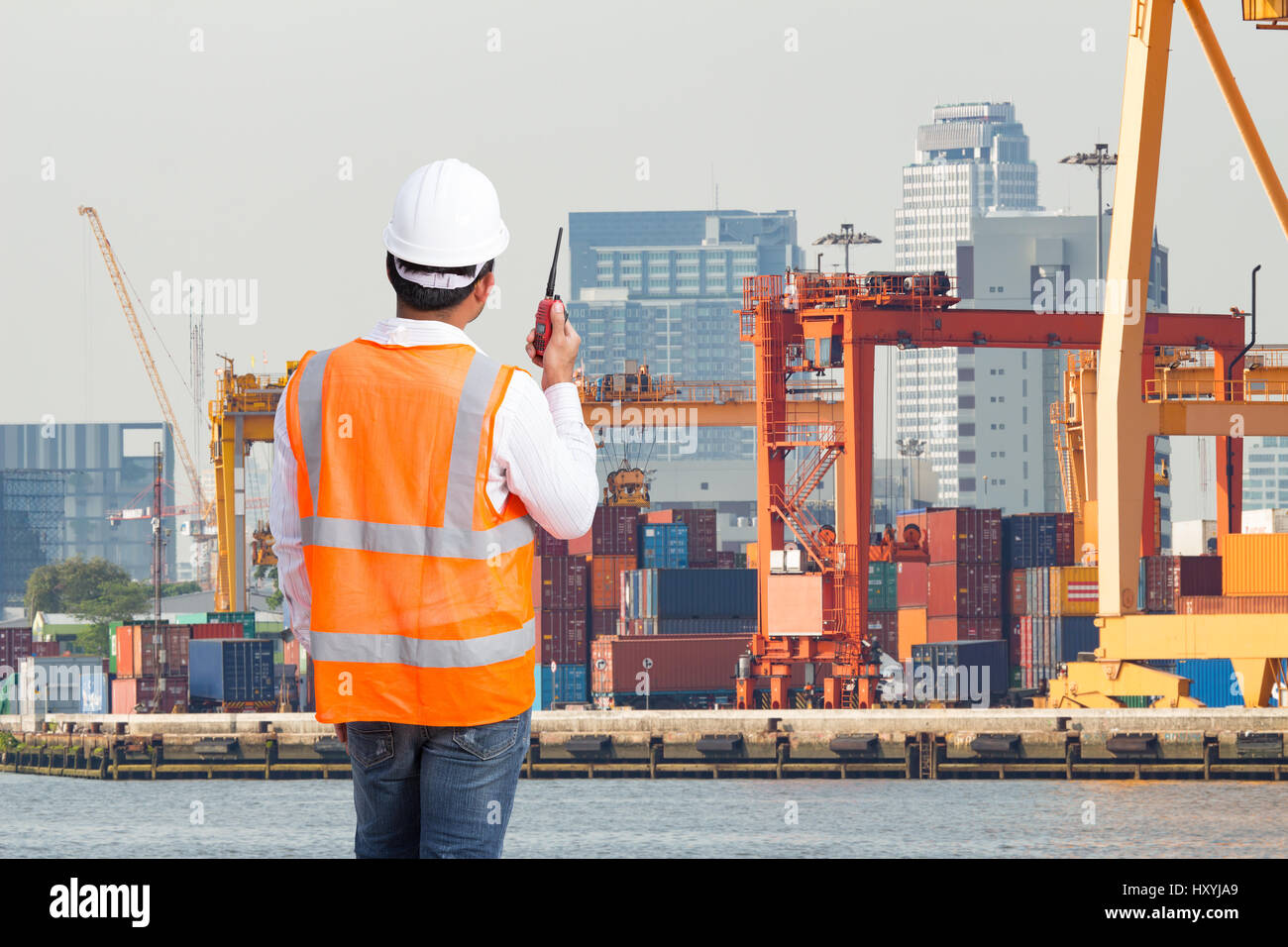 Dock worker talking on the walkie-talkie for controlling loading ...