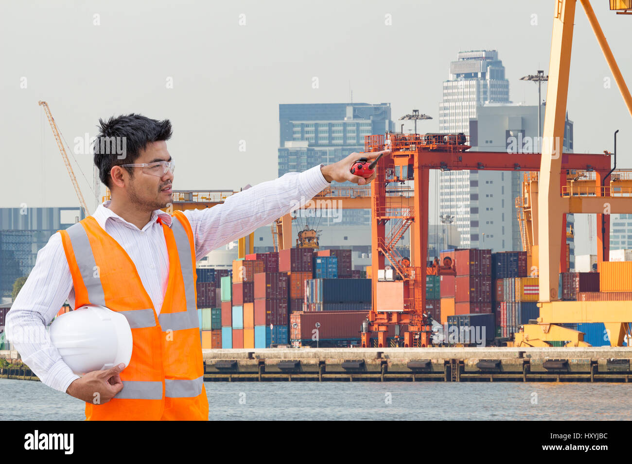 Port engineer standing in front of the industrial harbor with container ...