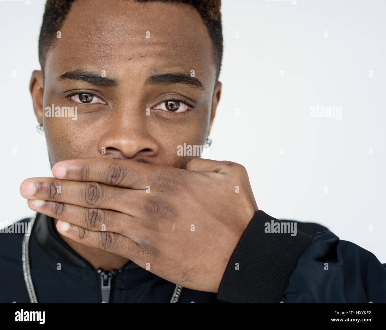 Black guy covering his mouth with hand Stock Photo - Alamy