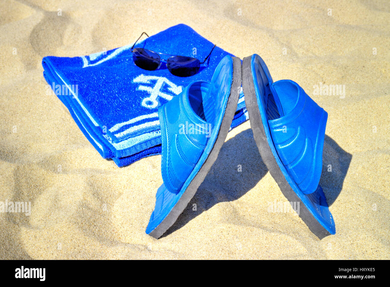 Sunglasses, blue towel and slippers on sandy beach Stock Photo - Alamy