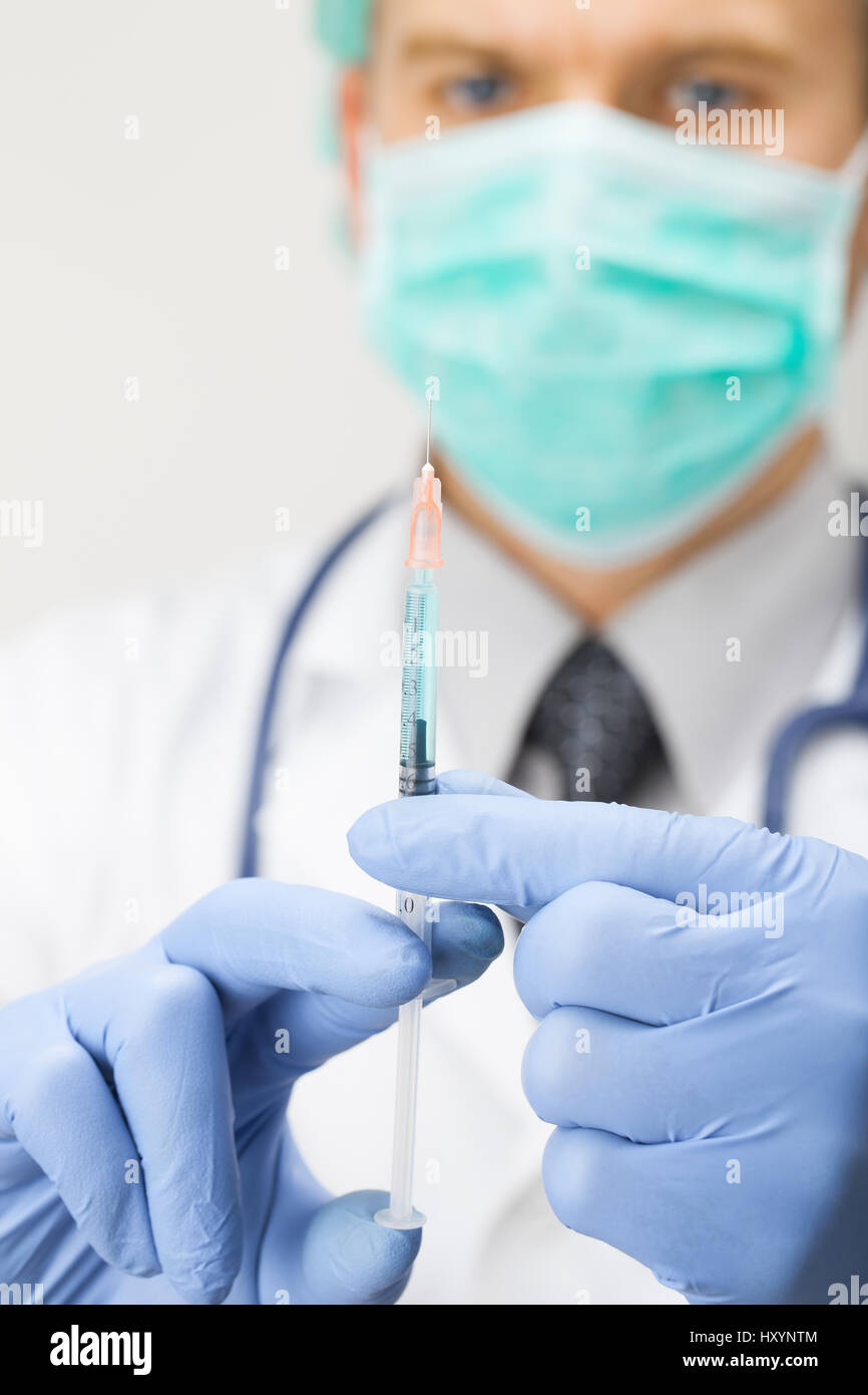 Doctor holding syringe and ready to make injection Stock Photo - Alamy