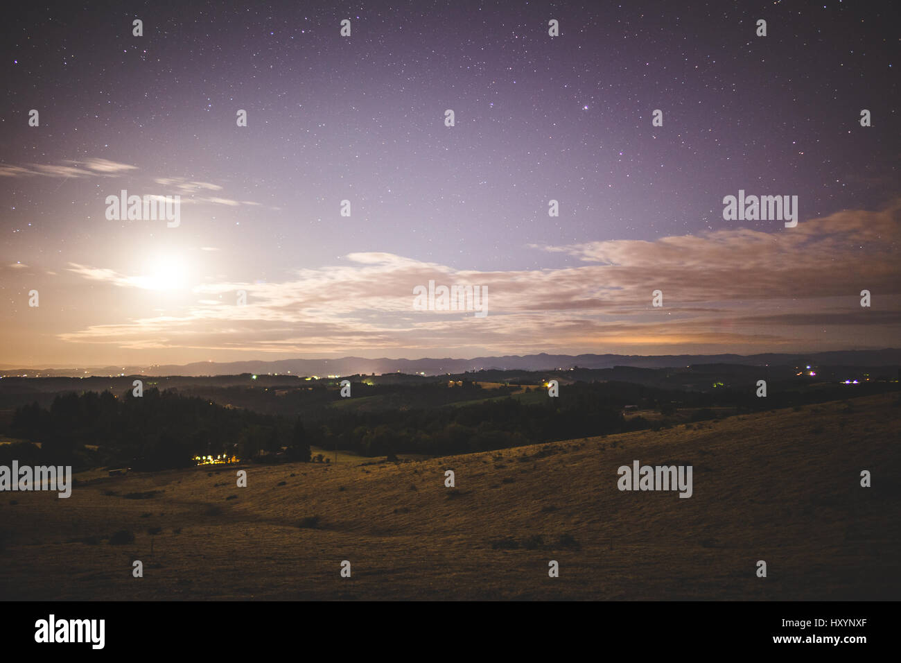 Night sky with bright moon over rolling hills Stock Photo - Alamy