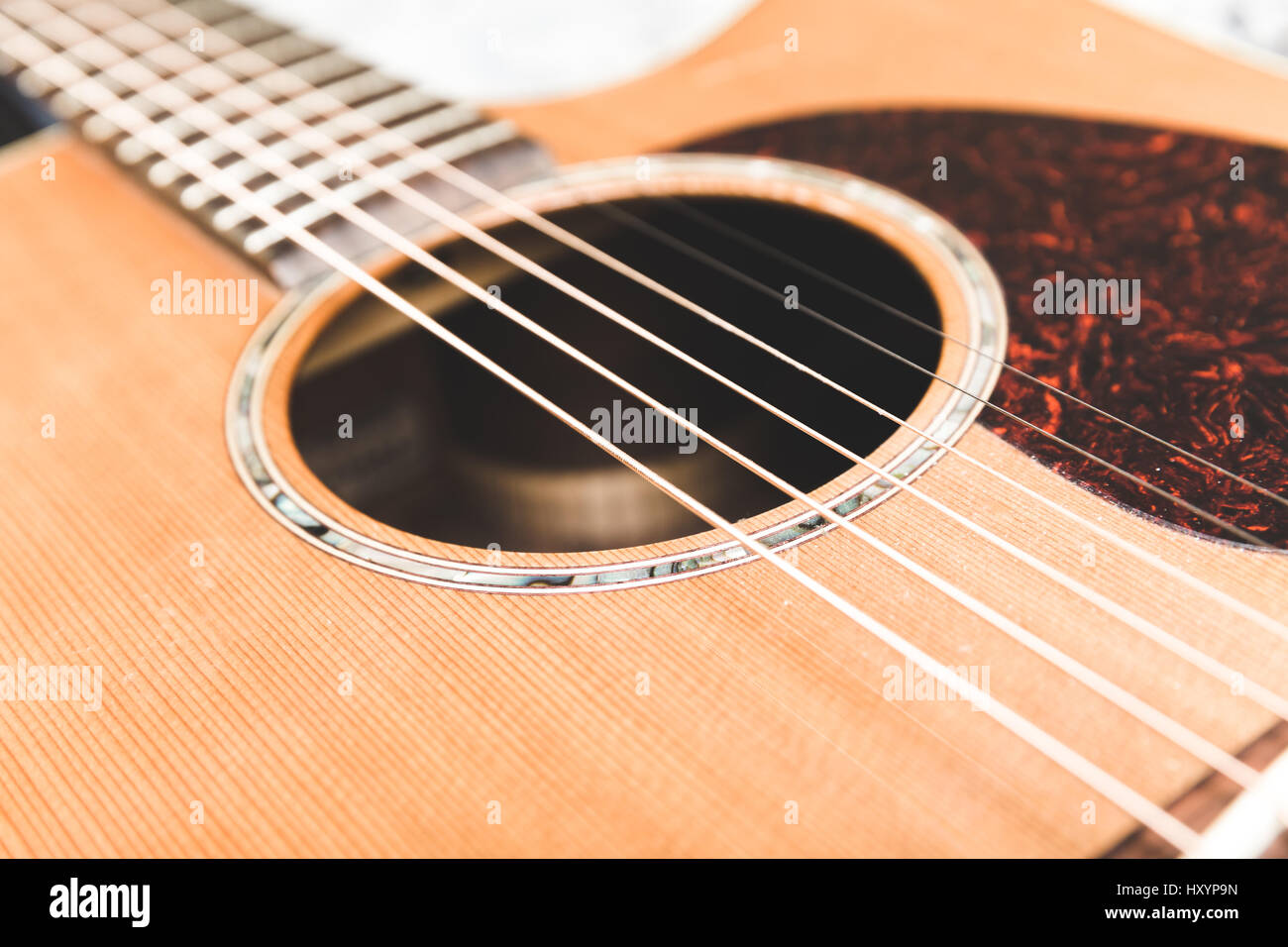 Closeup of steel strings and soundhole on an upscale acoustic guitar ...