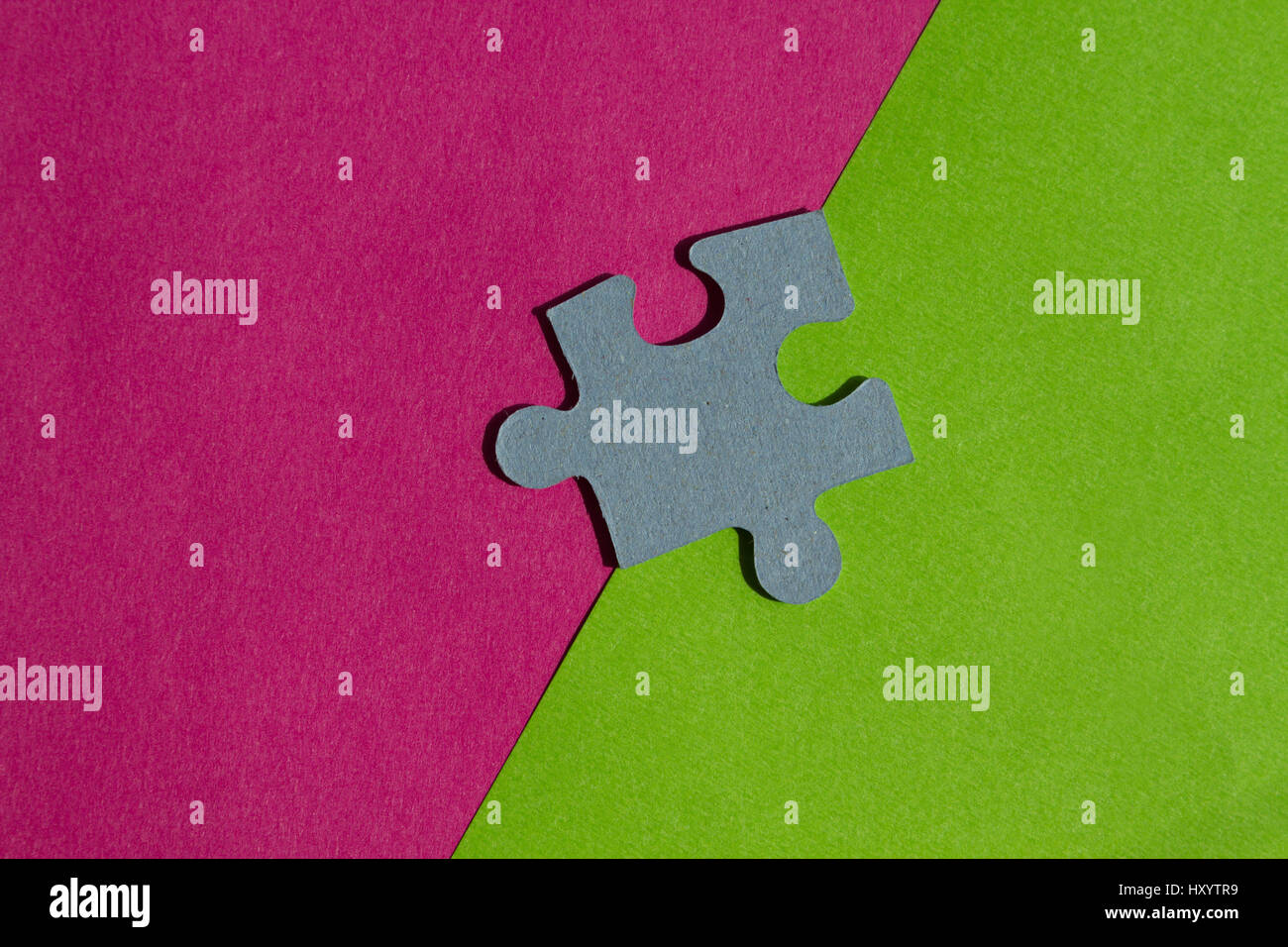 Jigsaw Puzzle pieces on border between pink and green background with ...