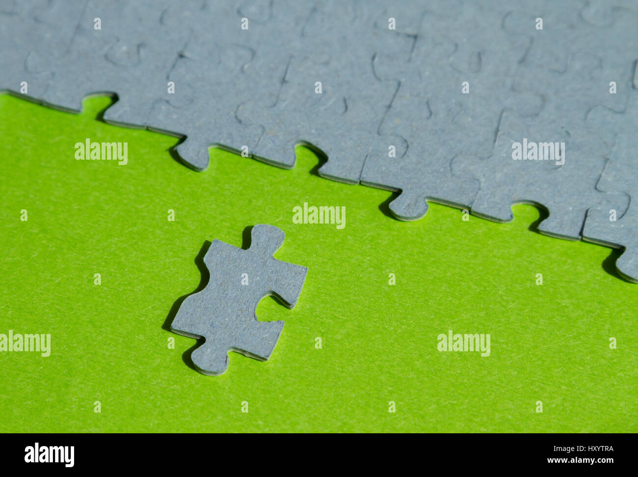 One jigsaw puzzle piece cut out on green background with copy space ...