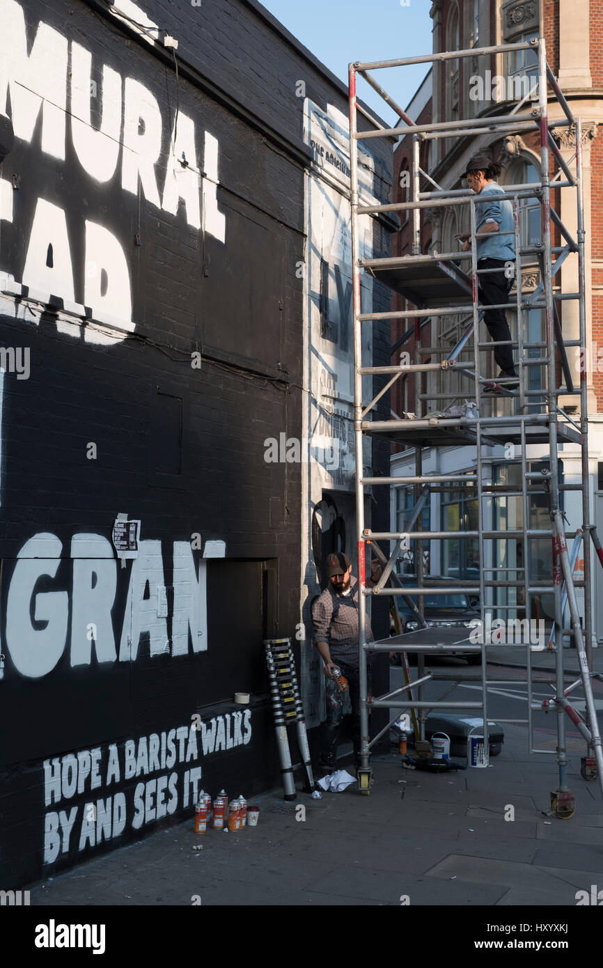 Street artists fix artwork in Shoreditch Stock Photo - Alamy