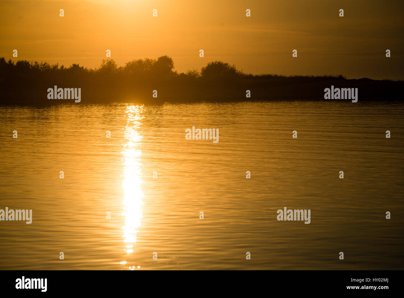 Beautiful summer sunset at the river with blue sky, red and orange ...