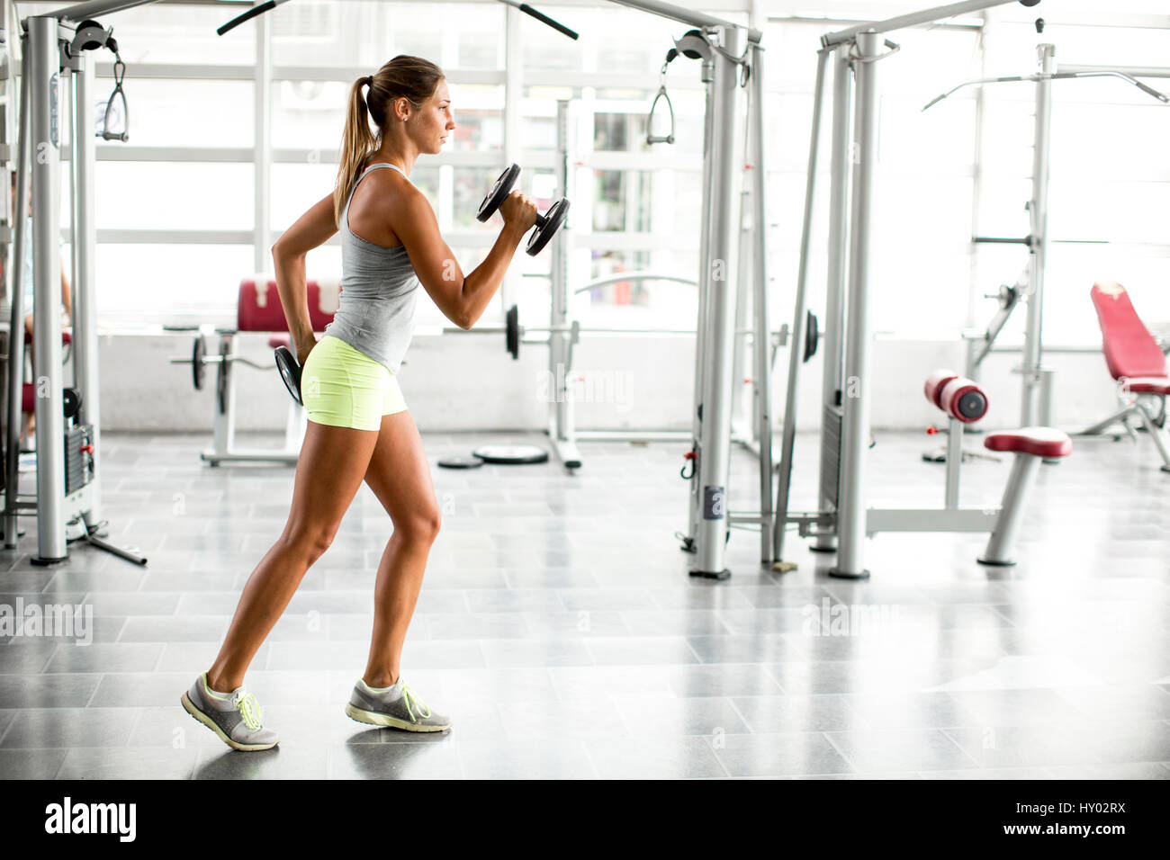 Young woman exercise with weights at the gym Stock Photo - Alamy
