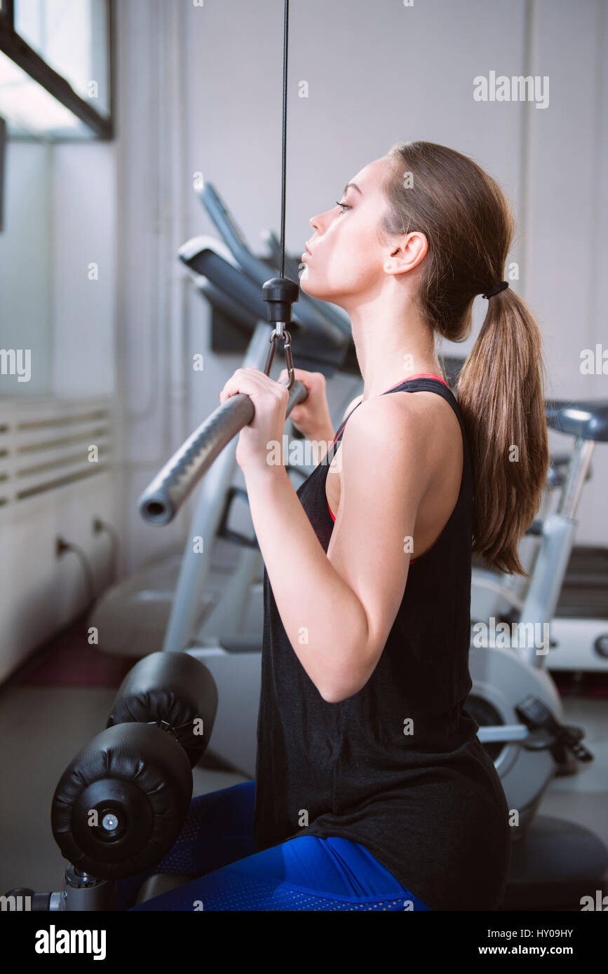 Young woman doing exercises on a machine at the gym Stock Photo - Alamy