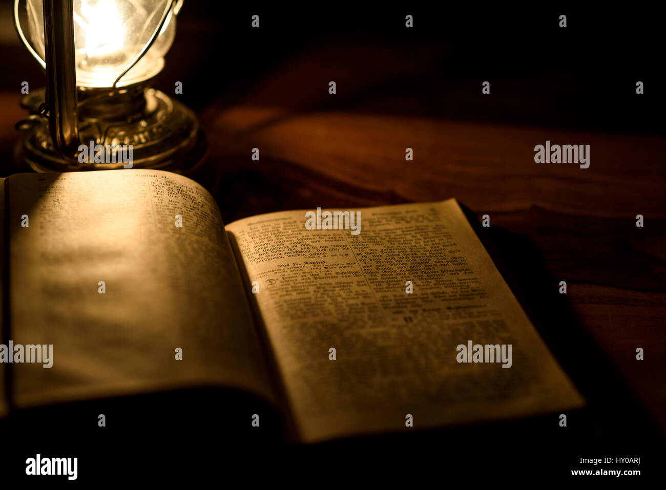 Bible in the light of an oil lamp Stock Photo - Alamy