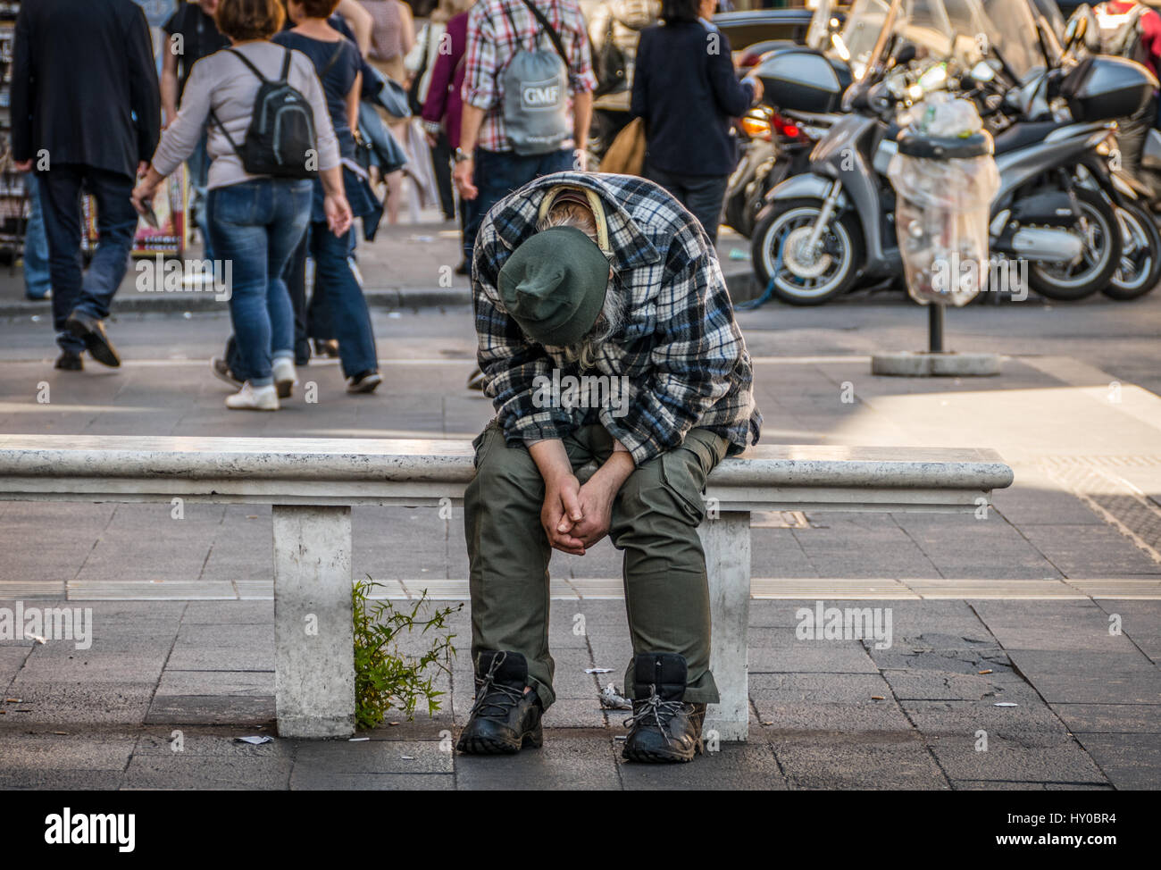 Homeless man sitting in a bench Stock Photo - Alamy