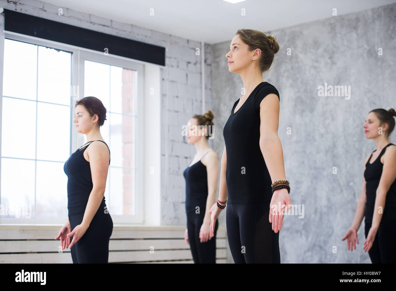 Women doing yoga sun salutation pose indoors at yoga studio Stock Photo ...