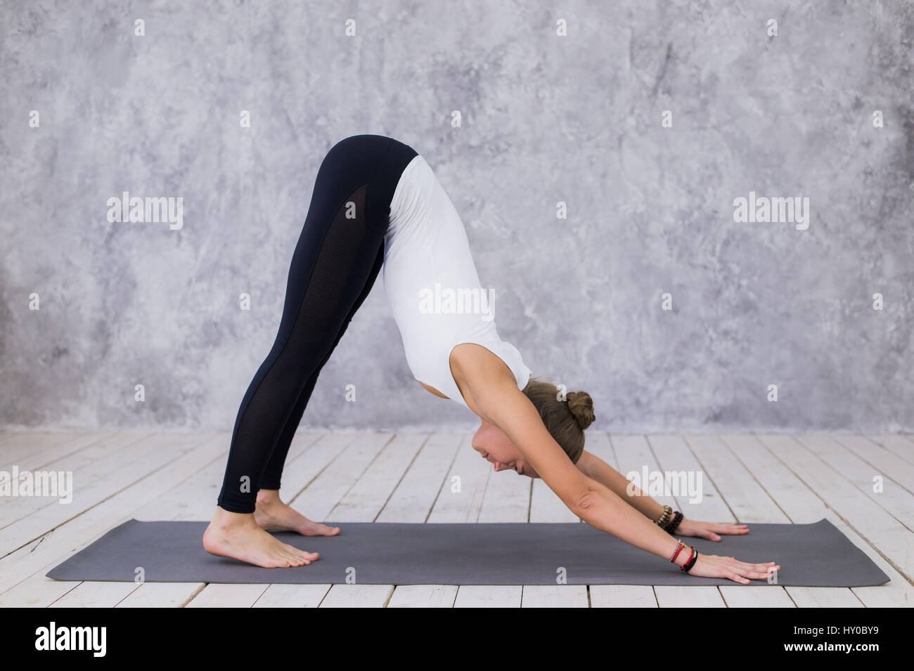 Beautiful young woman working out indoors, doing yoga exercise in the ...