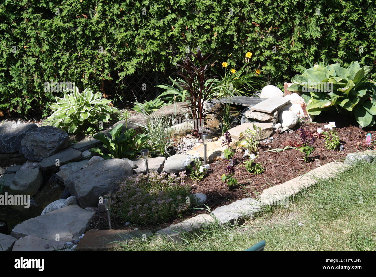 natural stone waterfall with surrounding garden Stock Photo - Alamy