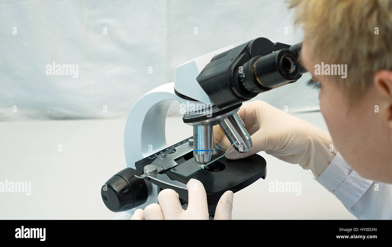 Female doctor scientist looking through microscope Stock Photo - Alamy