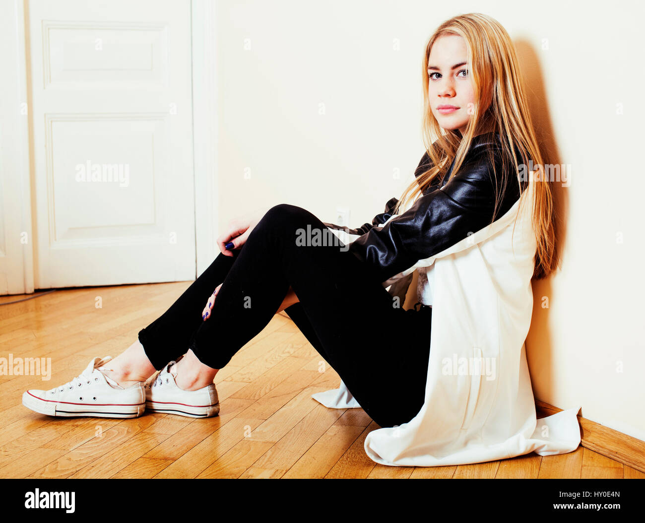 young pretty teenage blond girl sitting on floor at home despair Stock ...