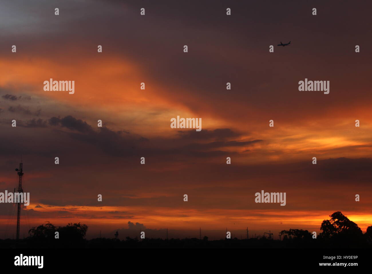 Airplane over sunset Stock Photo - Alamy
