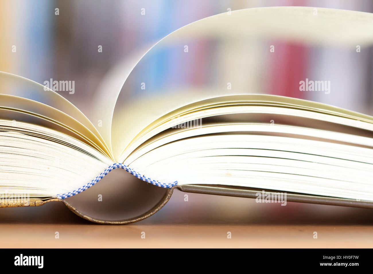 Close up opened book page with blurry bookshelf background for ...