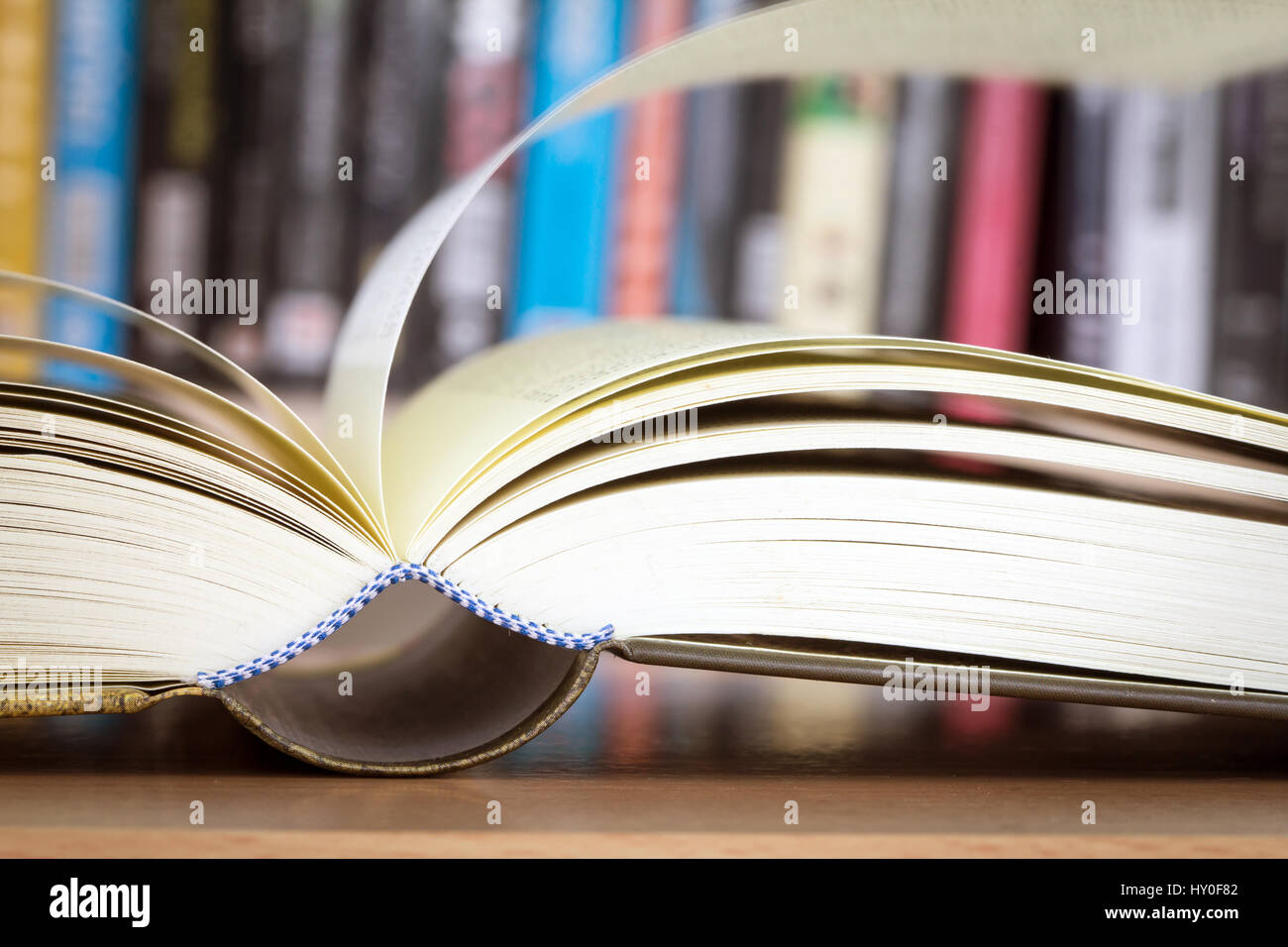Close up opened book page with blurry bookshelf background for ...