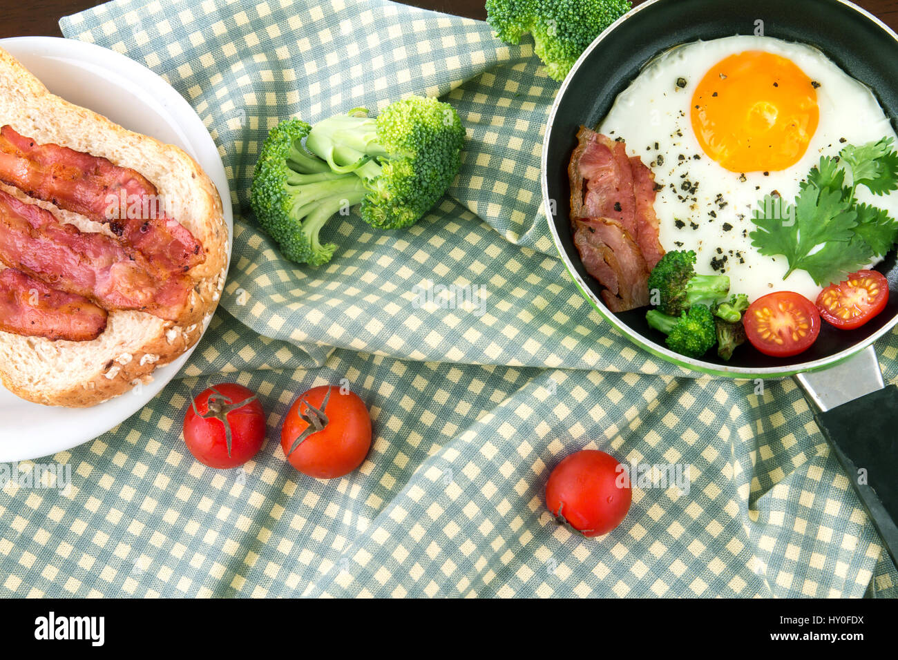Breakfast with fried egg and bacon in dark pan on the table Stock Photo ...