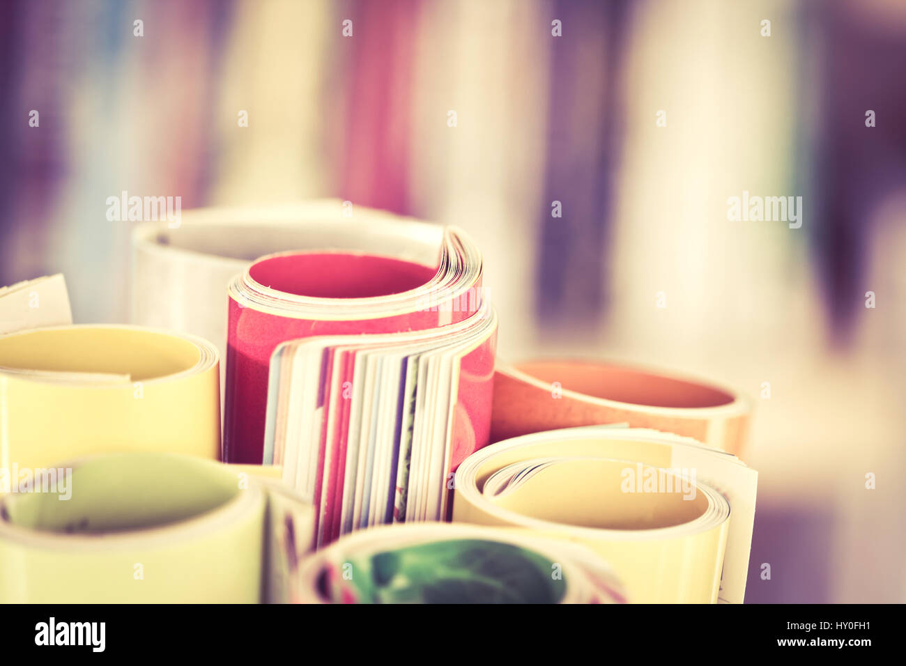 Close up edge of colorful magazine stacking roll with blurry bookshelf ...