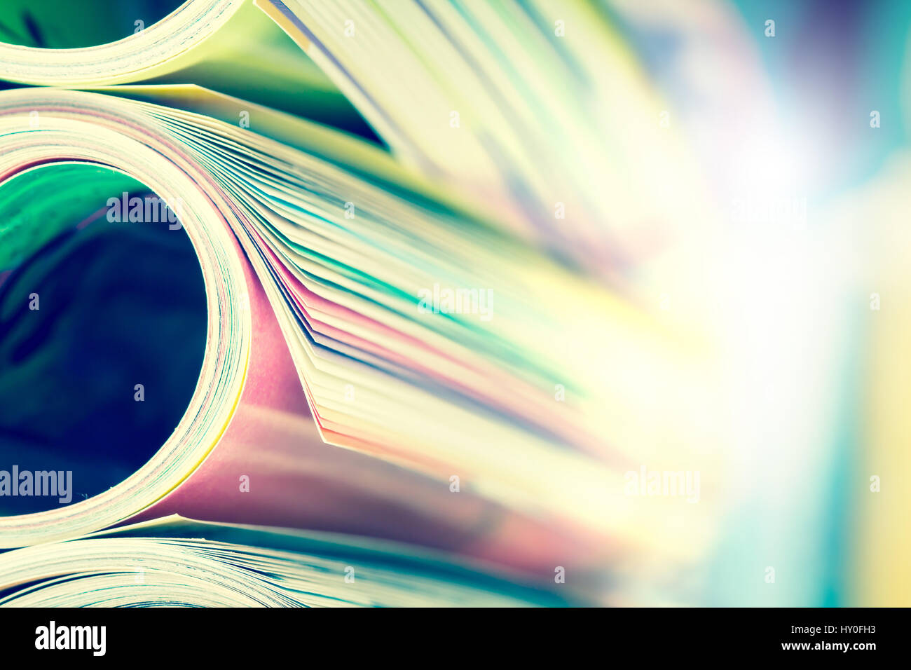 Close up edge of colorful magazine stacking roll with blurry bookshelf ...