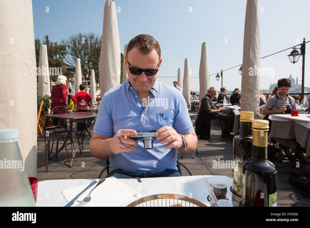 Man looking at pictures on his digital camera Stock Photo - Alamy