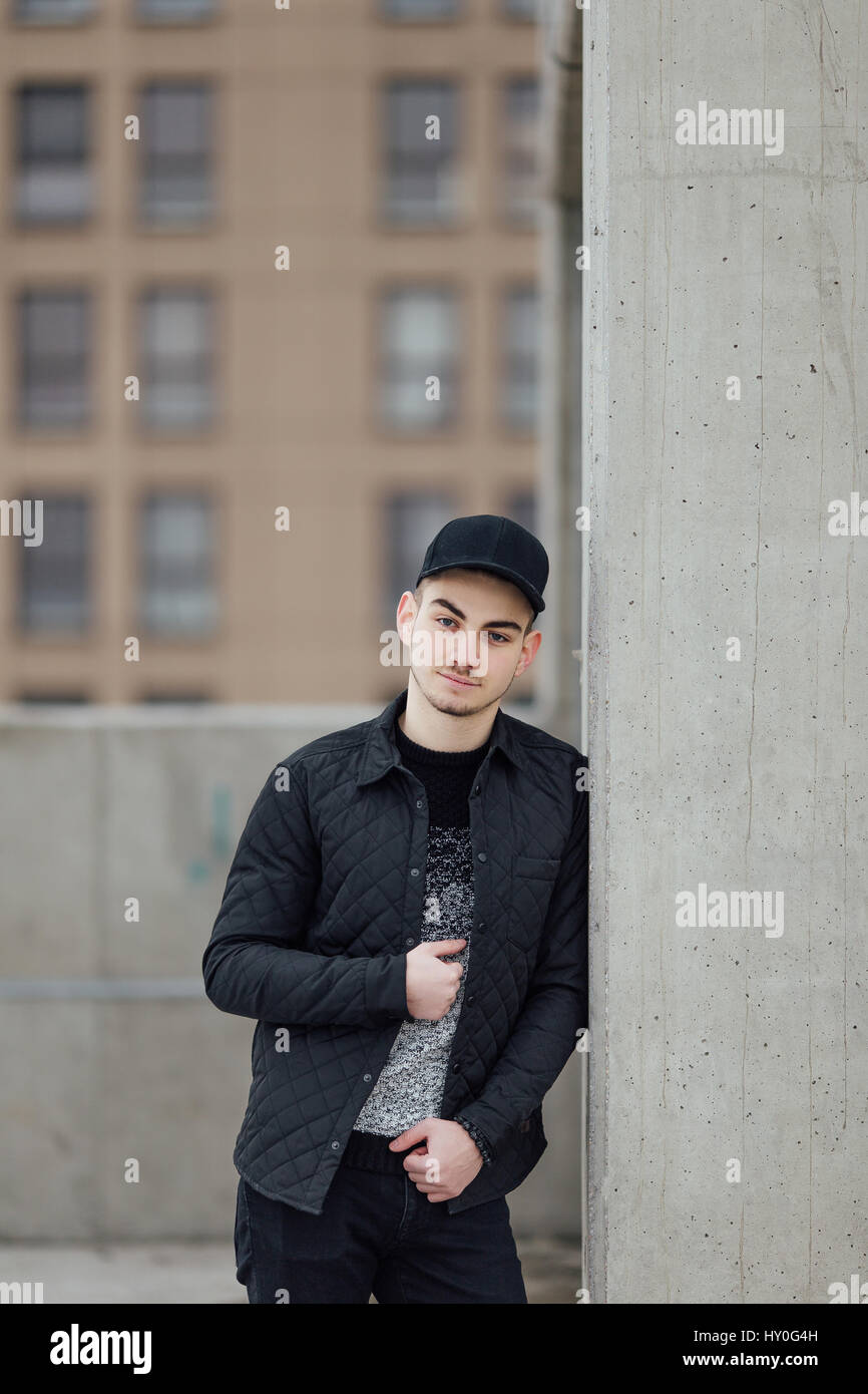 Fashionable man standing near wall with blur background Stock Photo - Alamy