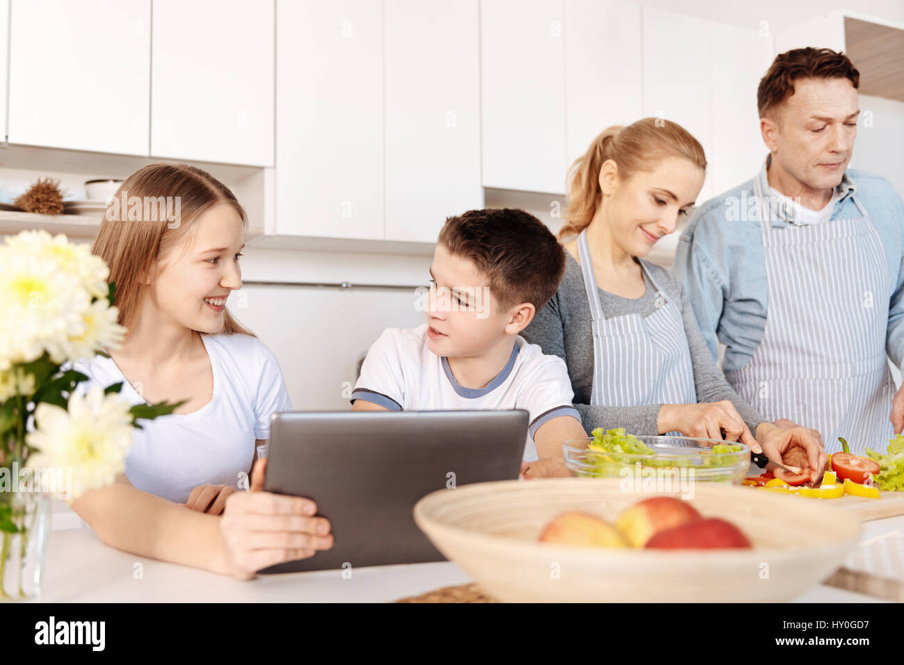 Enjoyable time together. Positive smiling siblings using tablet and ...