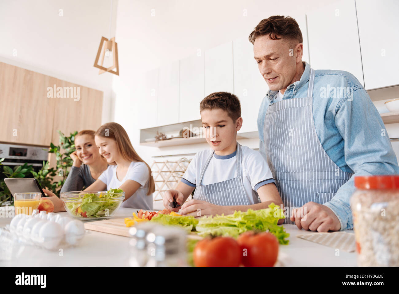 Involved in culinary. Pleasant little boy cooking with his father while ...