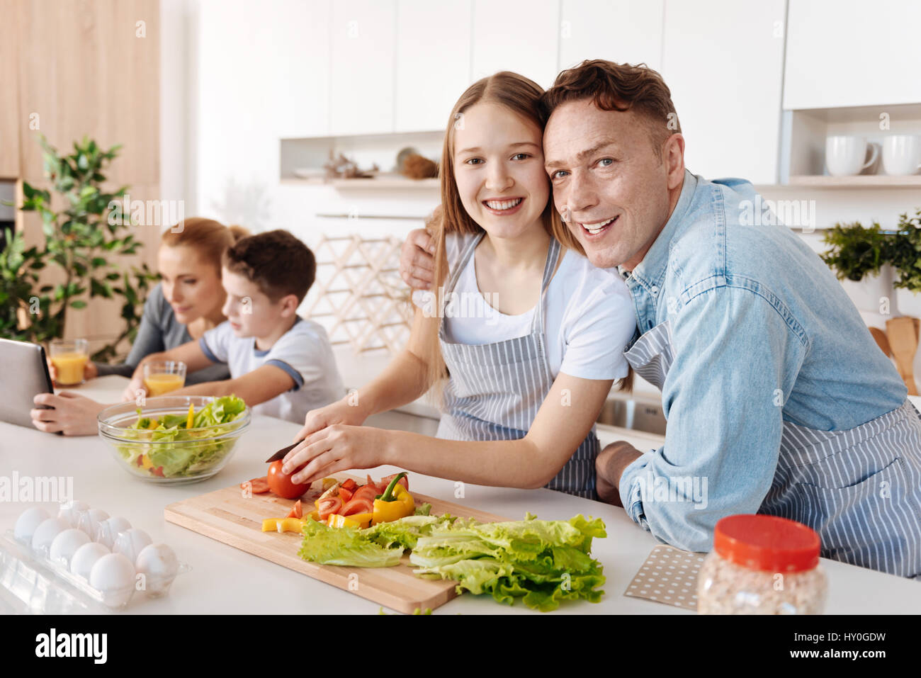 Enjoy every moment. Cheerful delighted smiling girl cooking with her ...