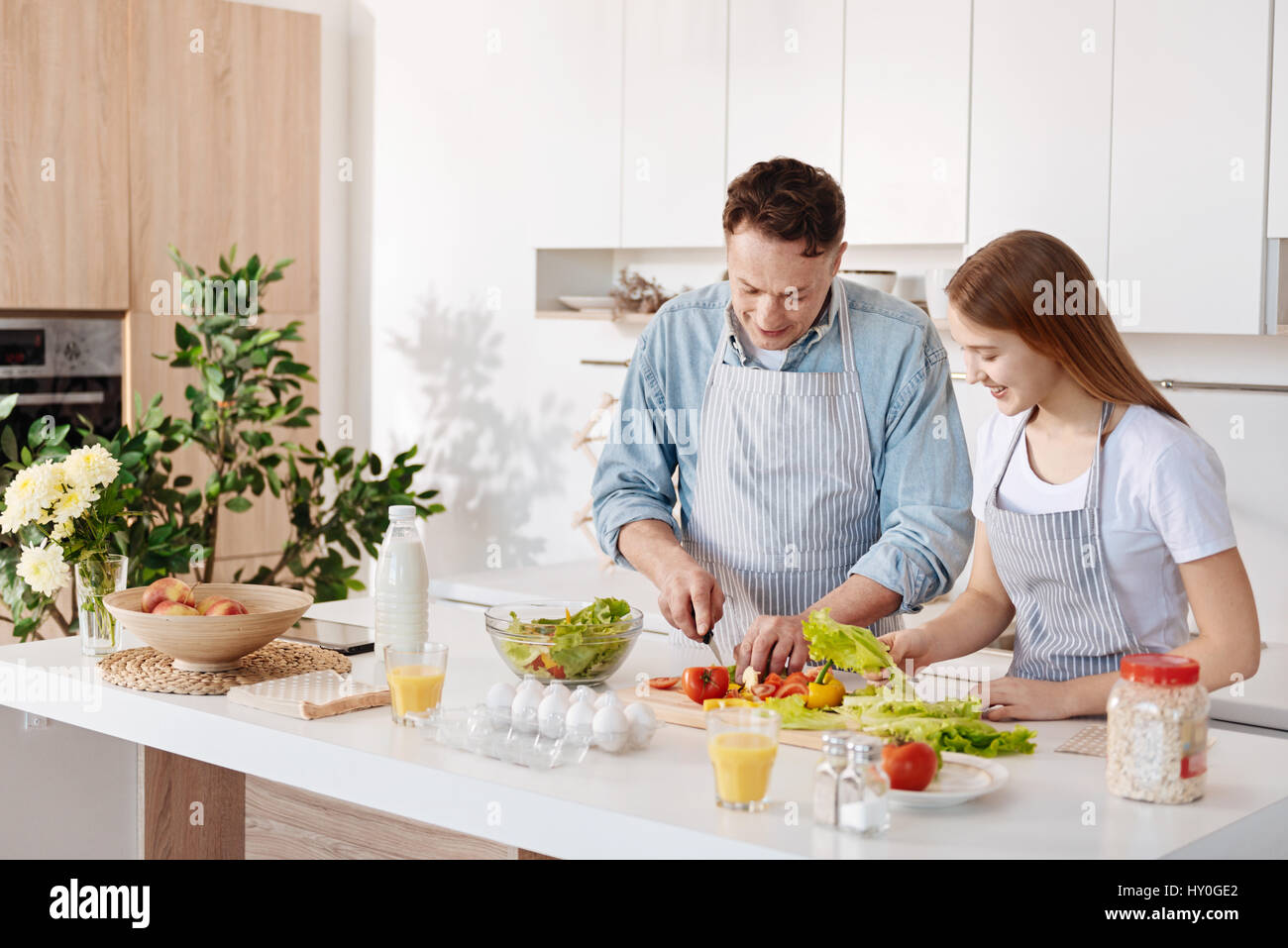 Like what you do. Cheerful caring father cookingith his daughter and ...