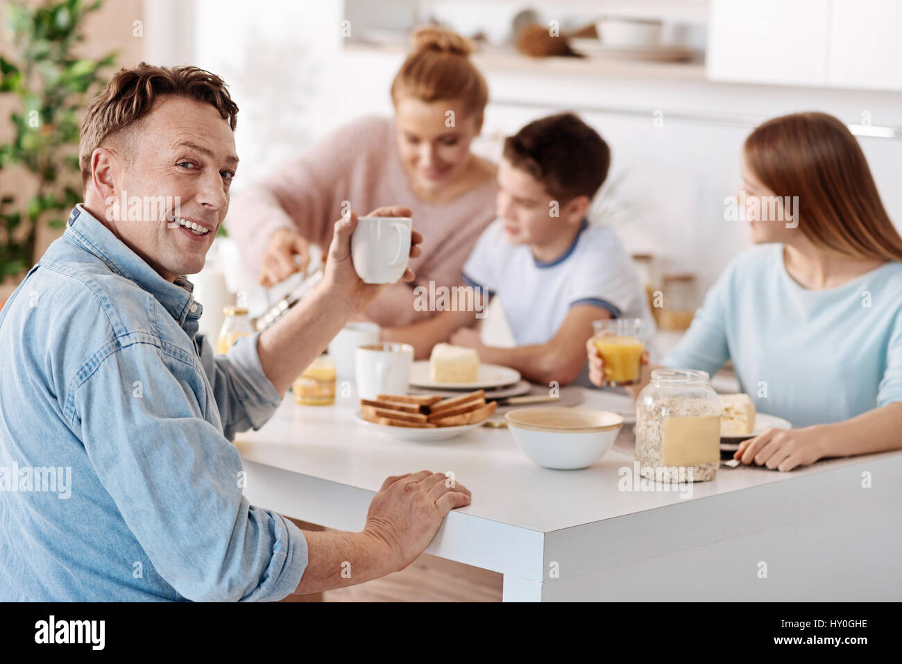 Proud of my family. Cheerful delighted man drinking tea and expressing ...