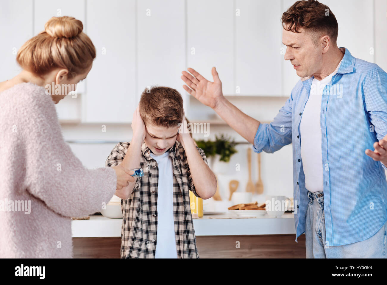 Bad behavior. Serious family couple scolding their son and warning him ...