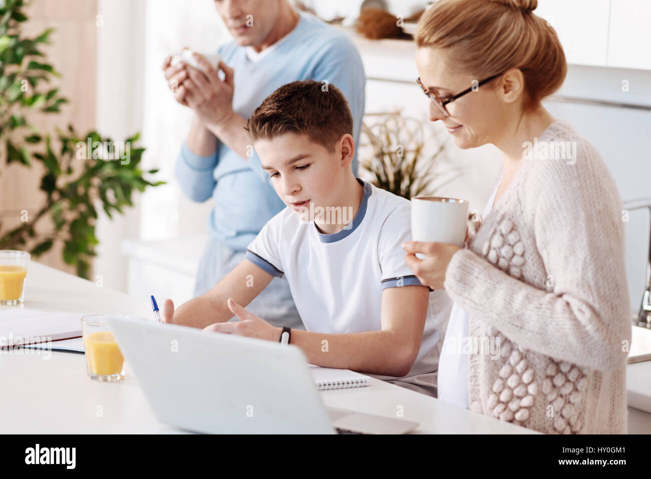 Caring mother checking home assignment of her son Stock Photo - Alamy