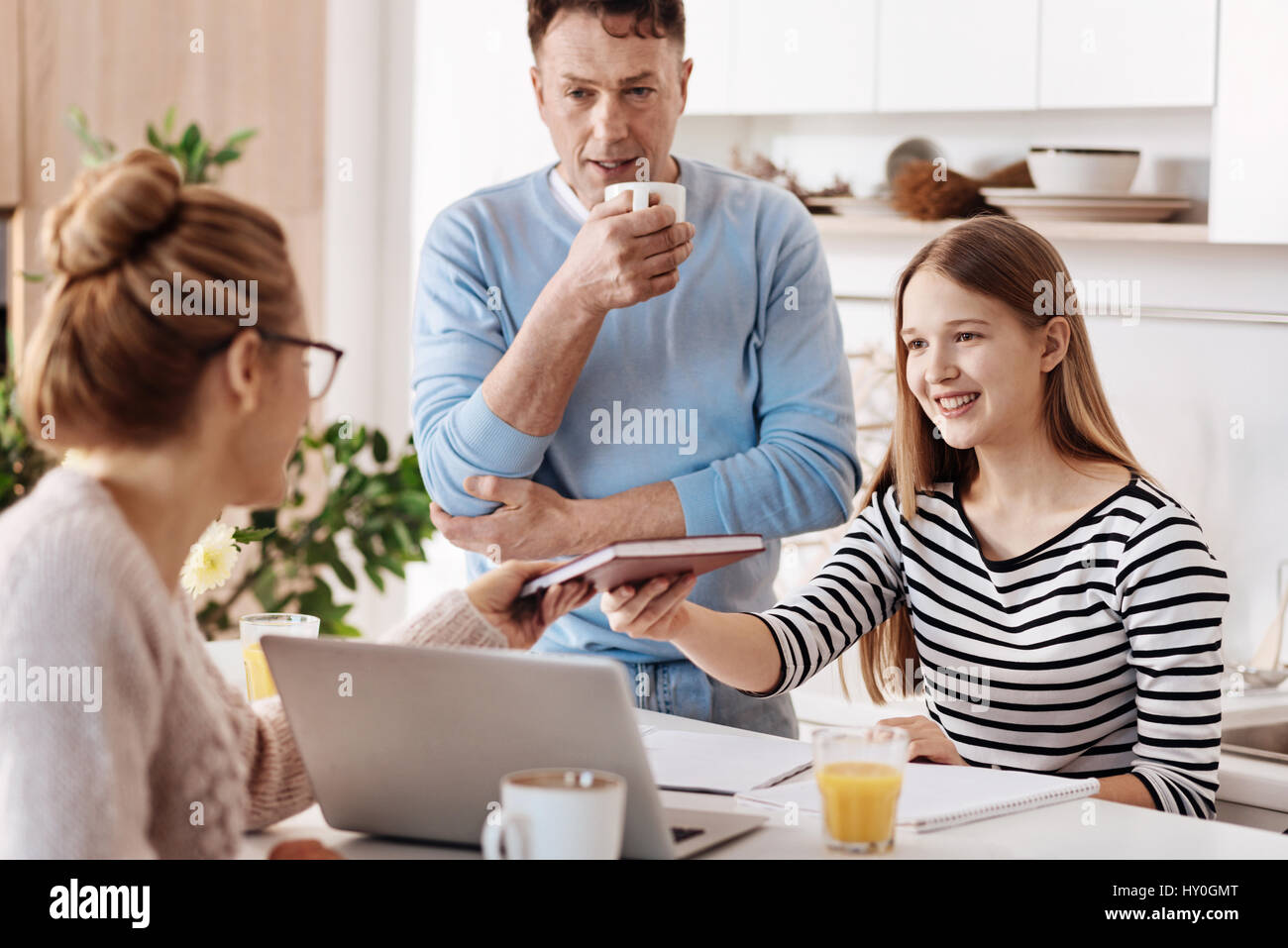 Positive parents checking homework of their daughter Stock Photo - Alamy
