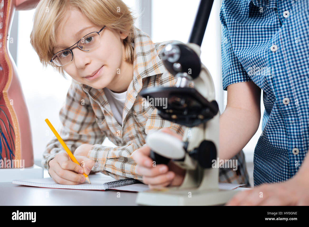 Intelligent young students working on biology project Stock Photo - Alamy