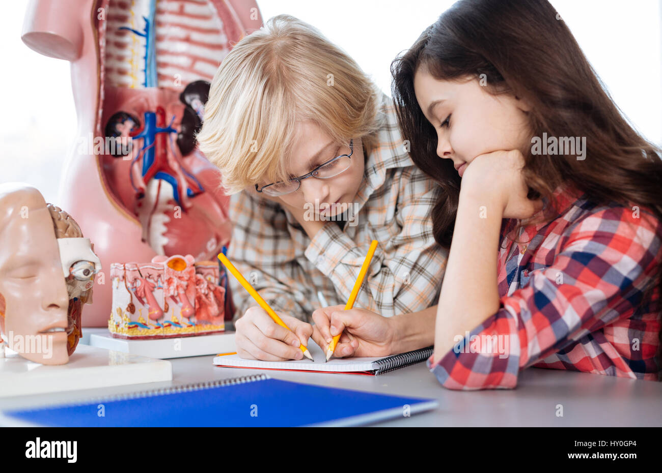 Thoughtful young students making notes Stock Photo - Alamy