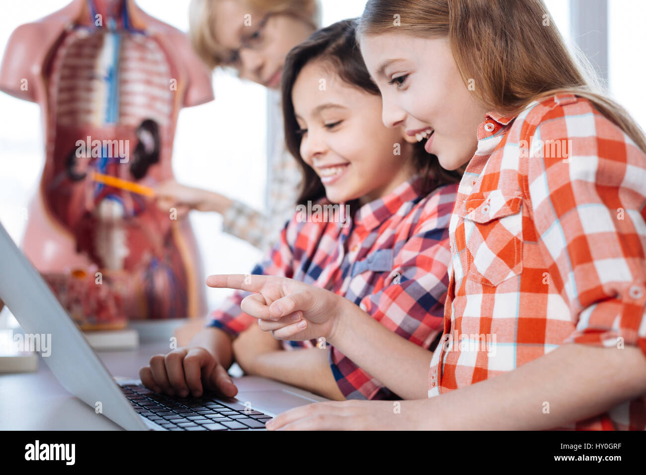 Admirable enthusiastic girls comparing pictures and models Stock Photo ...