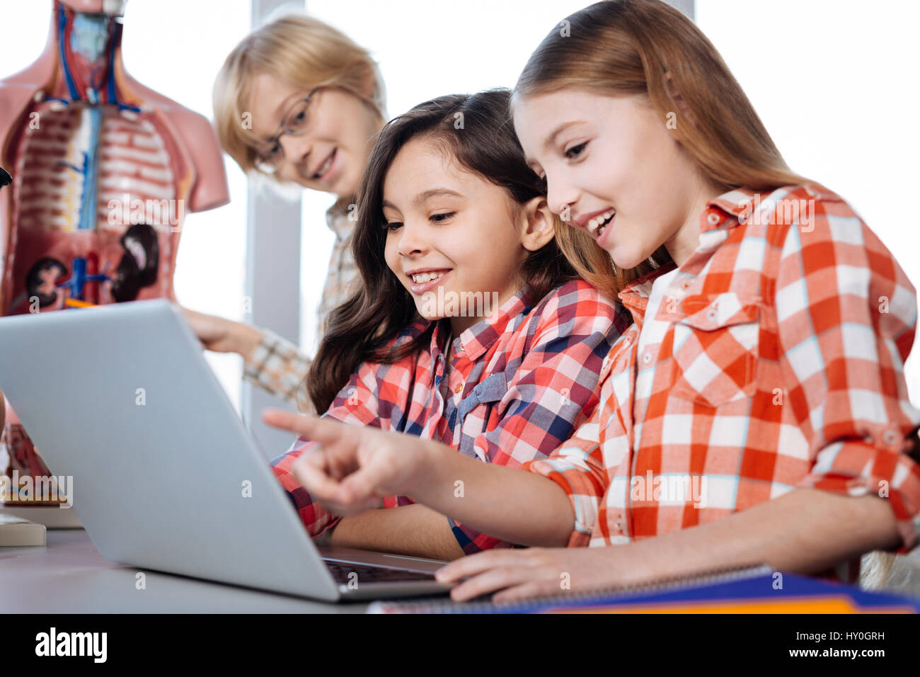 Lovely young ladies reading something on laptop Stock Photo - Alamy