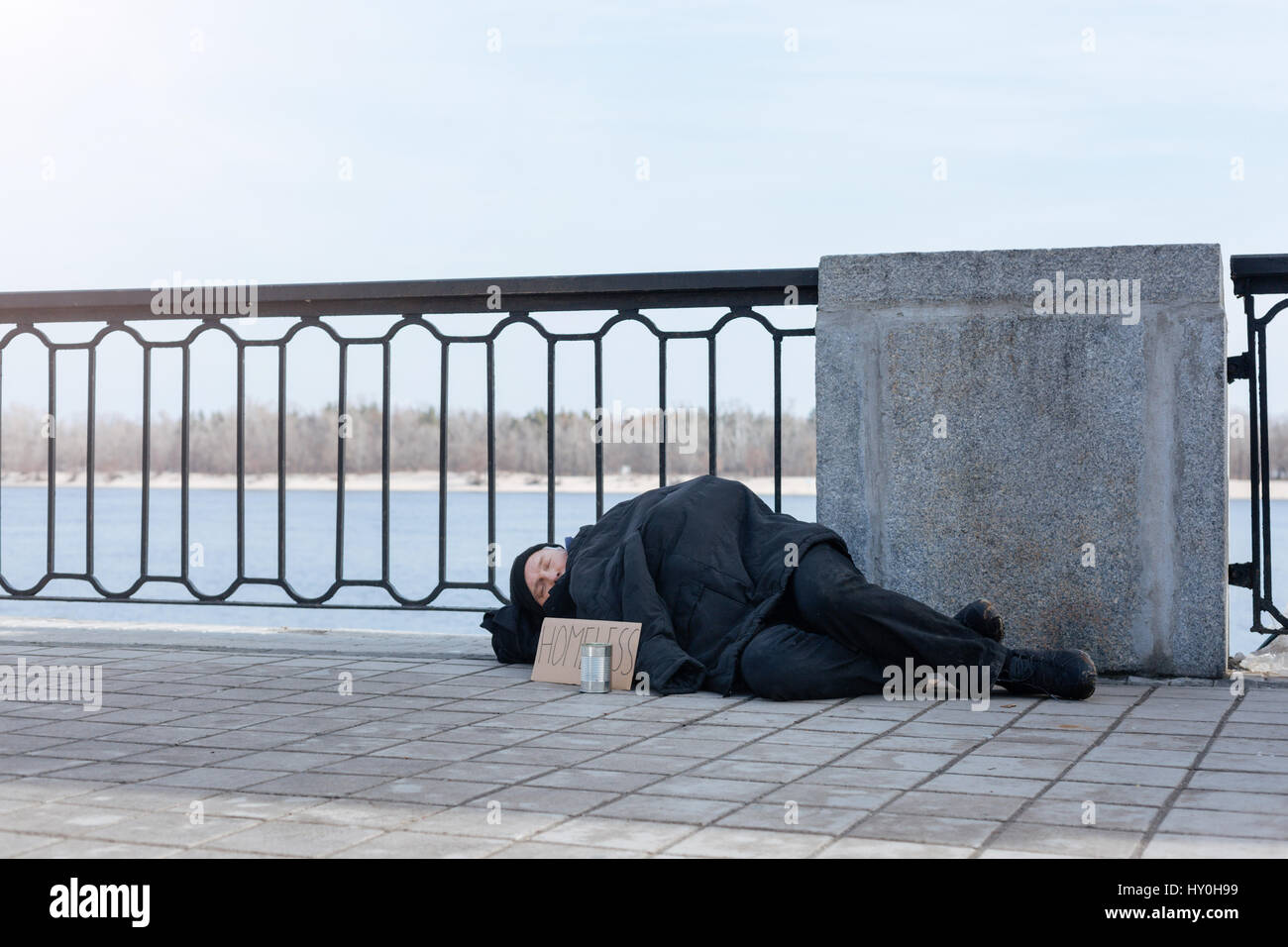 Homeless person covering himself with jacket Stock Photo - Alamy