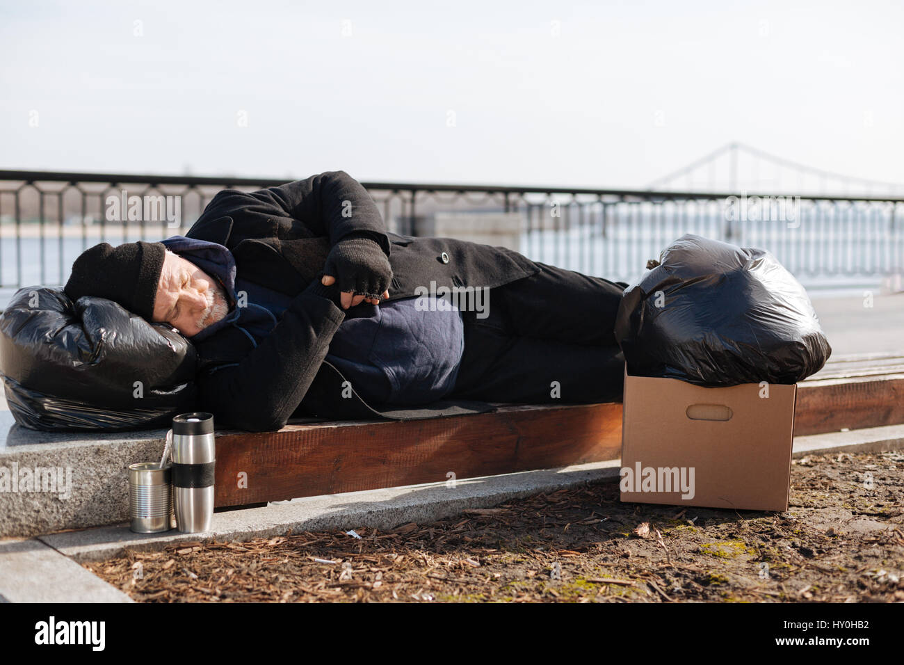 Tired man putting his head on the garbage bag Stock Photo - Alamy