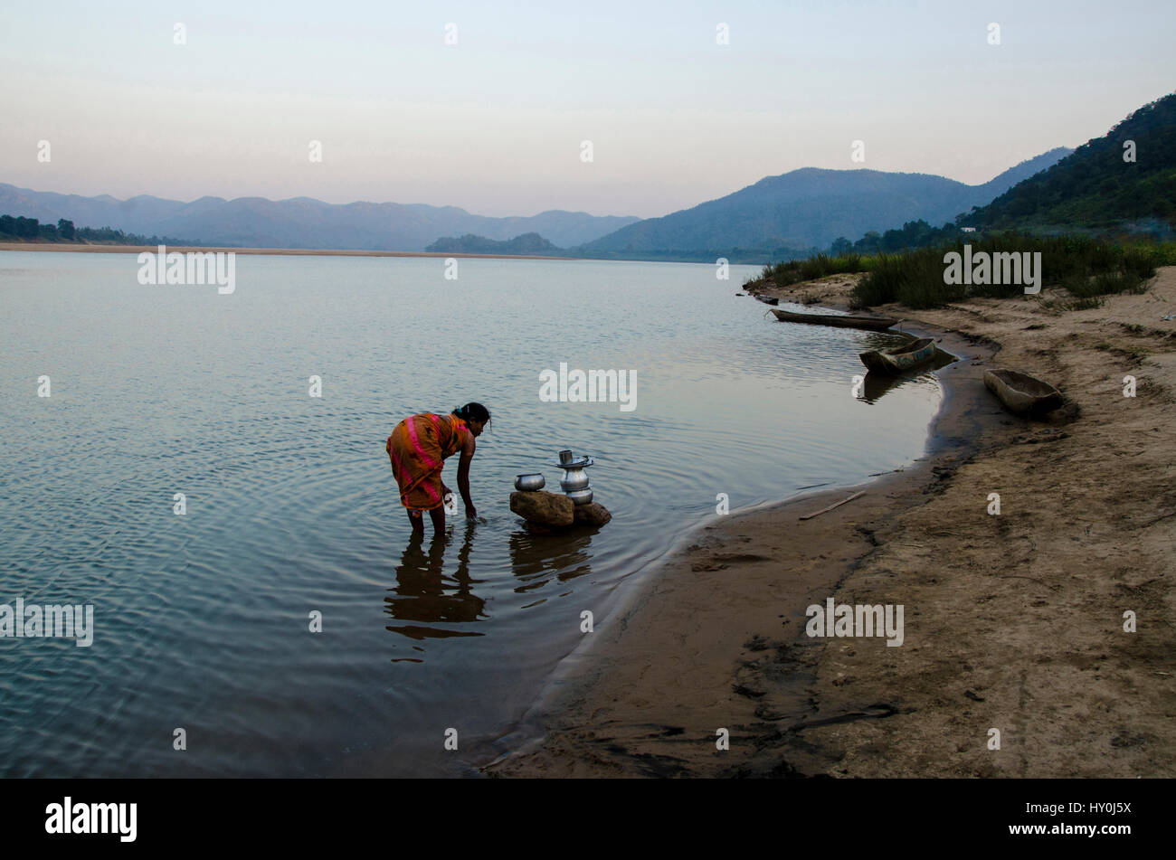 Tribal woman filling water pot from river water, papikondalu, andhra ...