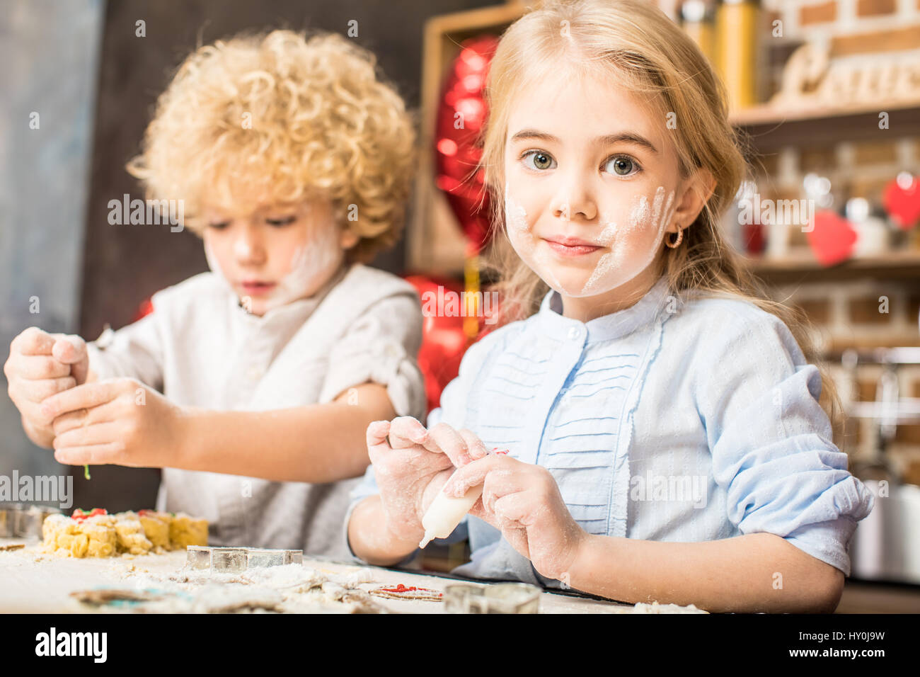 Portrait of little boy and girl making cookies in kitchen Stock Photo ...